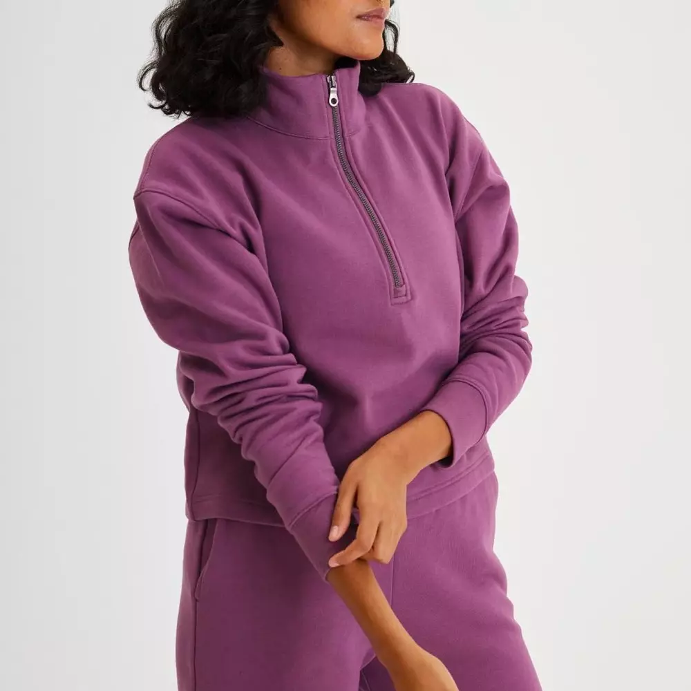 模特身穿 Girlfriend Collective Tulipwood 50/50 紫色半拉链运动衫