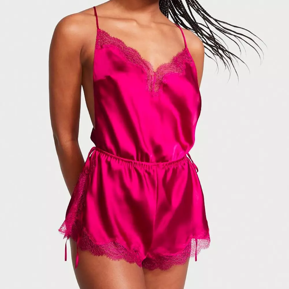 Malli, jolla on yllään vaaleanpunainen Victoria's Secret Satin & Lace Lace-Up Romperi